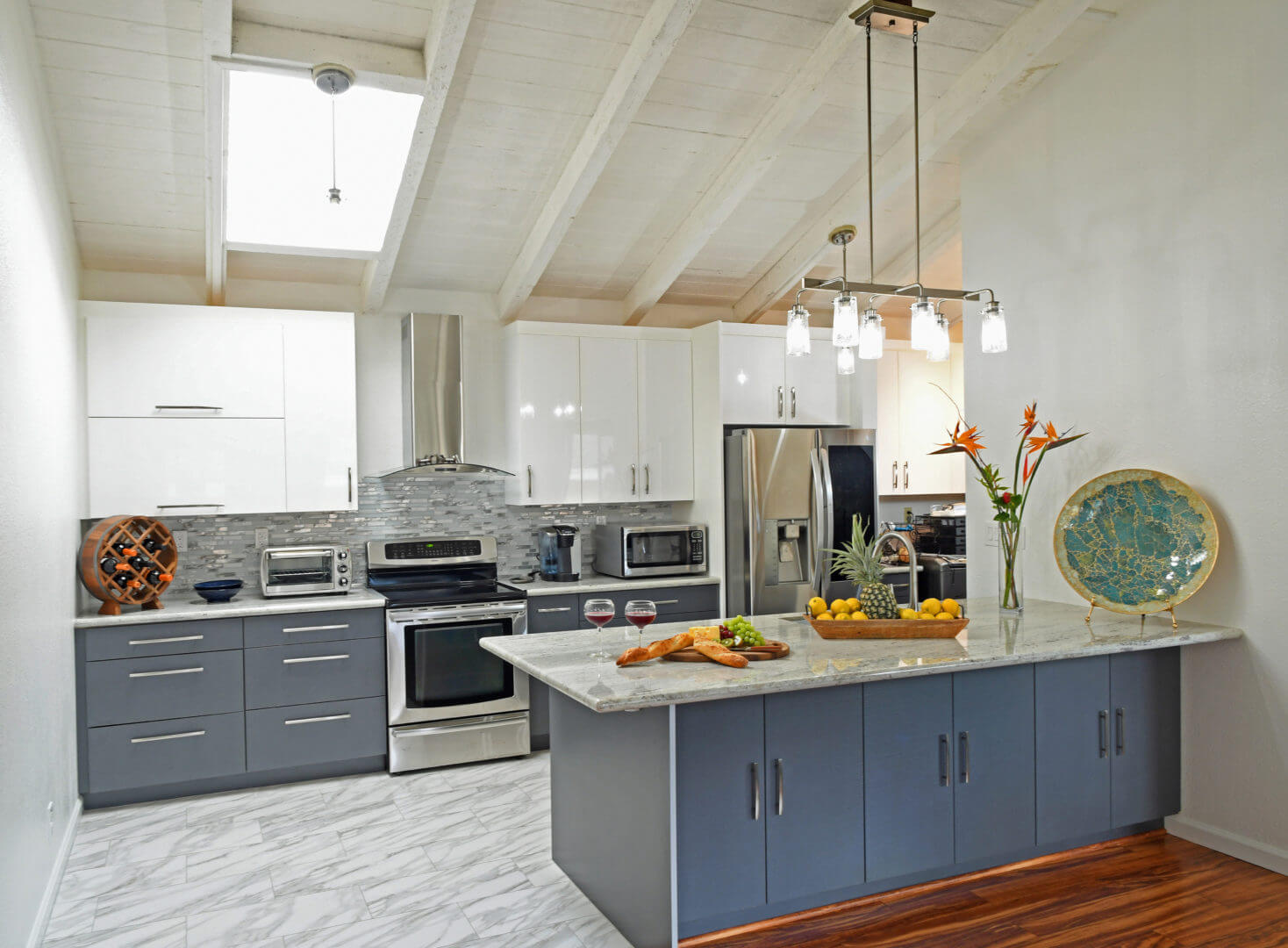 A kitchen with a large island and white cabinets. - Open Concept ...
